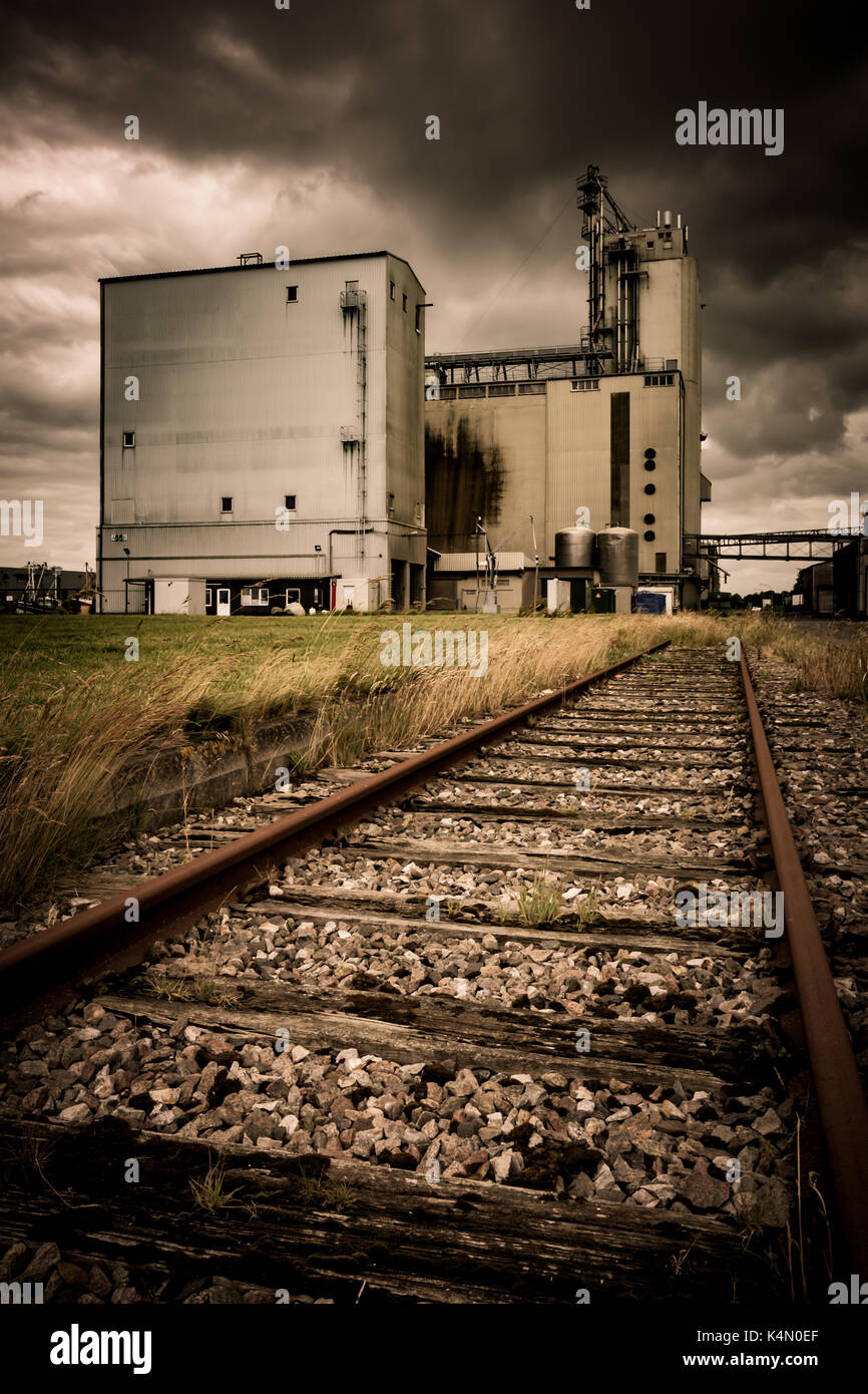 Railroad tracks leading to old abandoned factory Stock Photo - Alamy