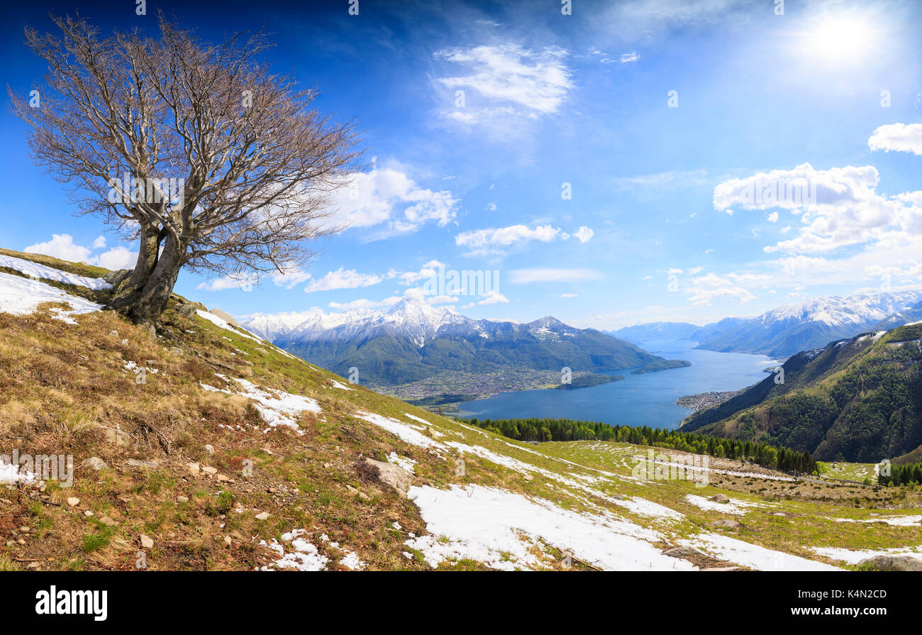 Panorama of meadows partially covered with snow with Lake Como on the ...