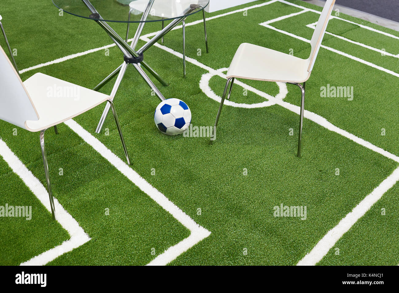 Floor covering as a soccer field and a table and chairs Stock Photo - Alamy