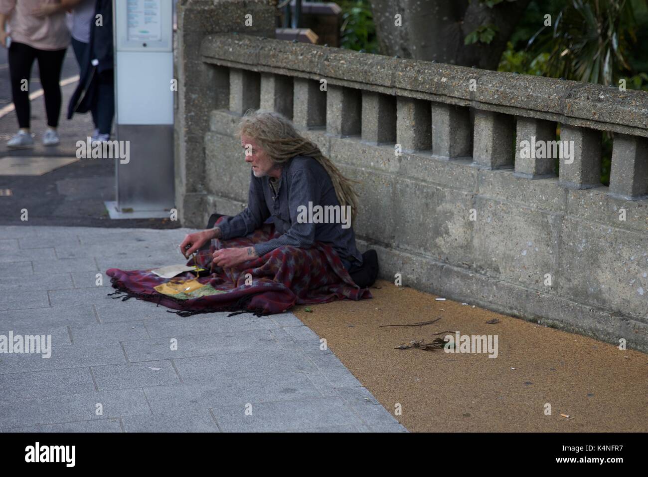 Homeless man sat down on the street Stock Photo - Alamy
