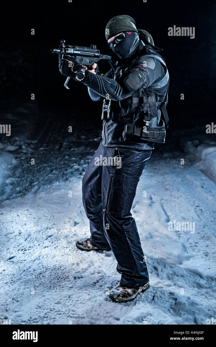 Strong man military special forces standing with gun on snow at night ...
