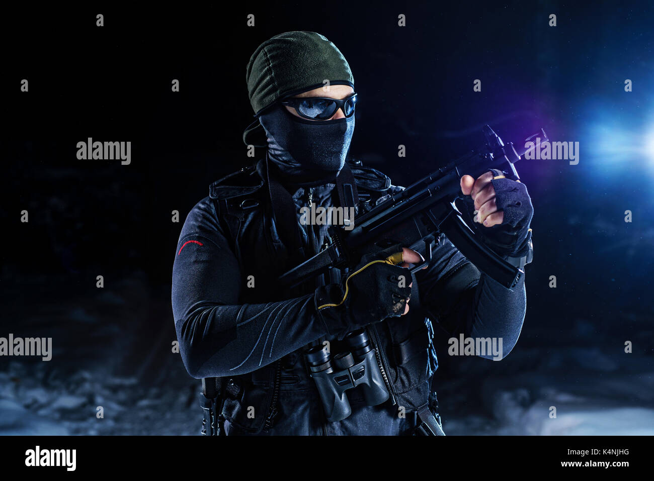 Strong man military special forces standing with gun on snow at night ...