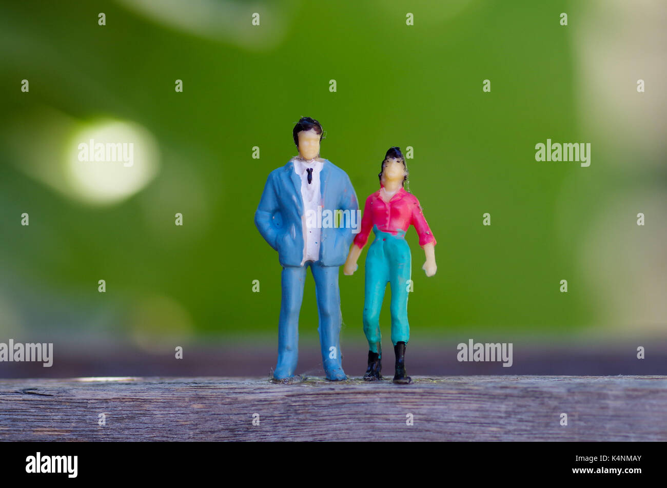 Miniature little people couple over a computer keyboard, in a blurred ...