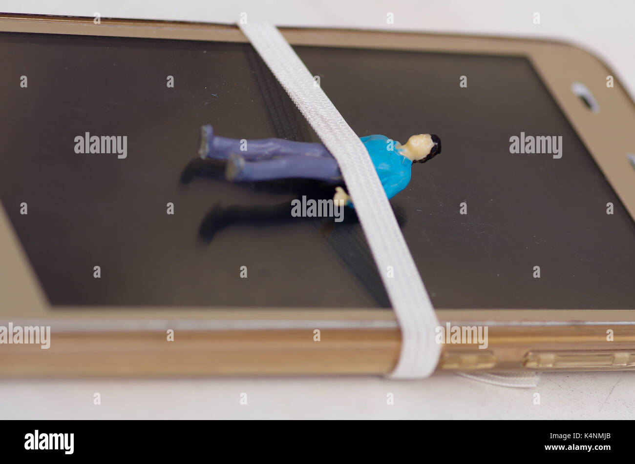 Miniature little people, prisioner over a screen of a tablet, in a ...