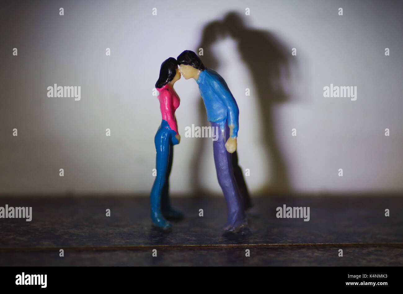 Miniature little people, couple kissing with a shadow behind Stock ...