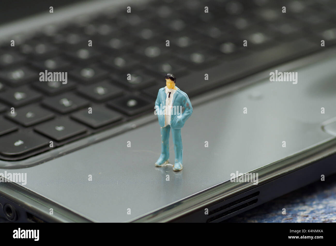 Miniature little people man over a computer keyboard, in a blurred ...