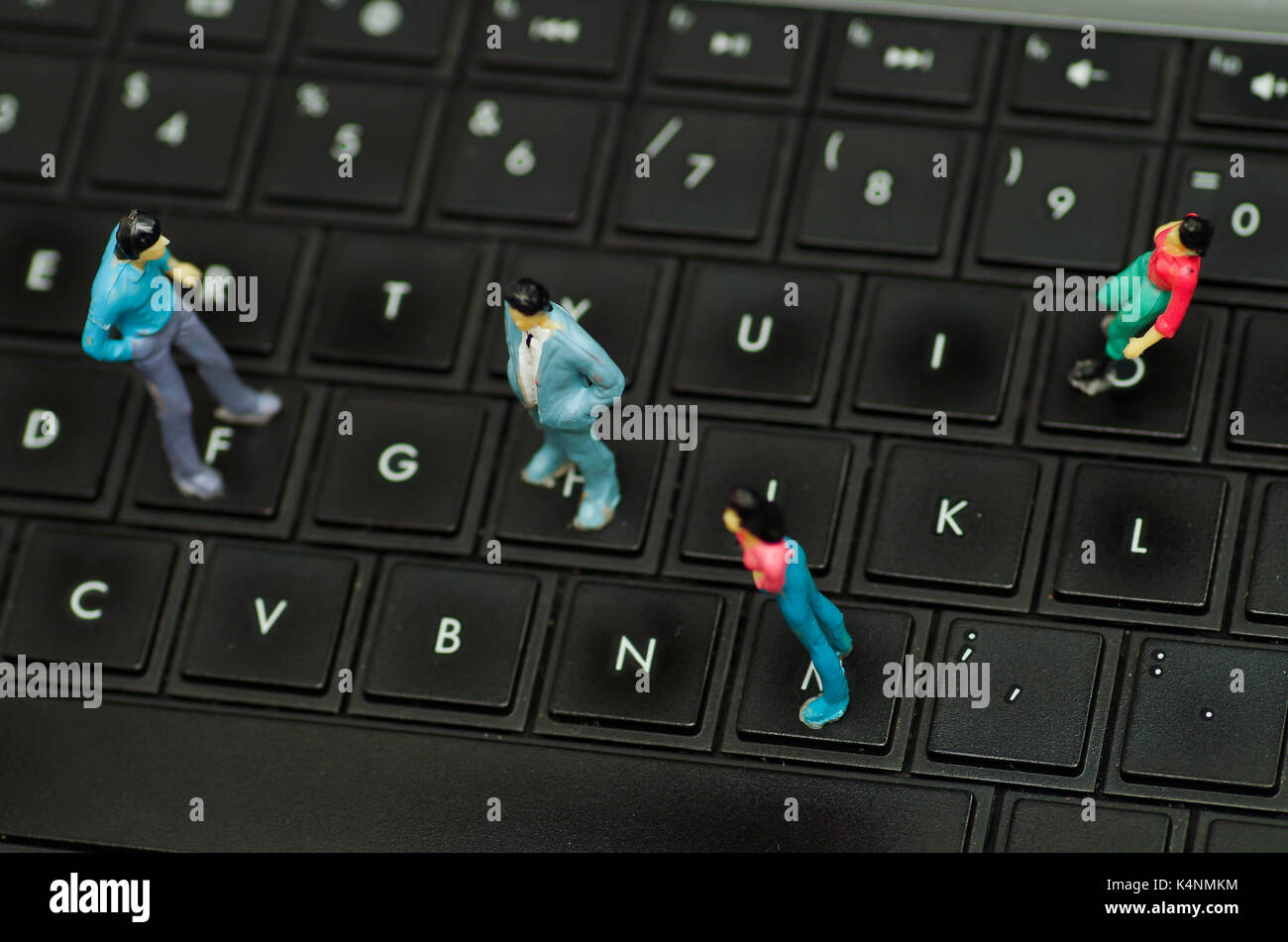 Miniature little people, group of friends over a computer keyboard, in ...