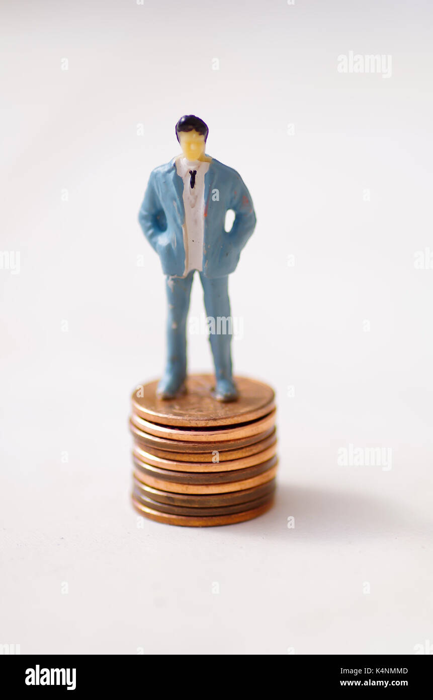 Miniature little people, man posing over a pile of one cents in a white ...