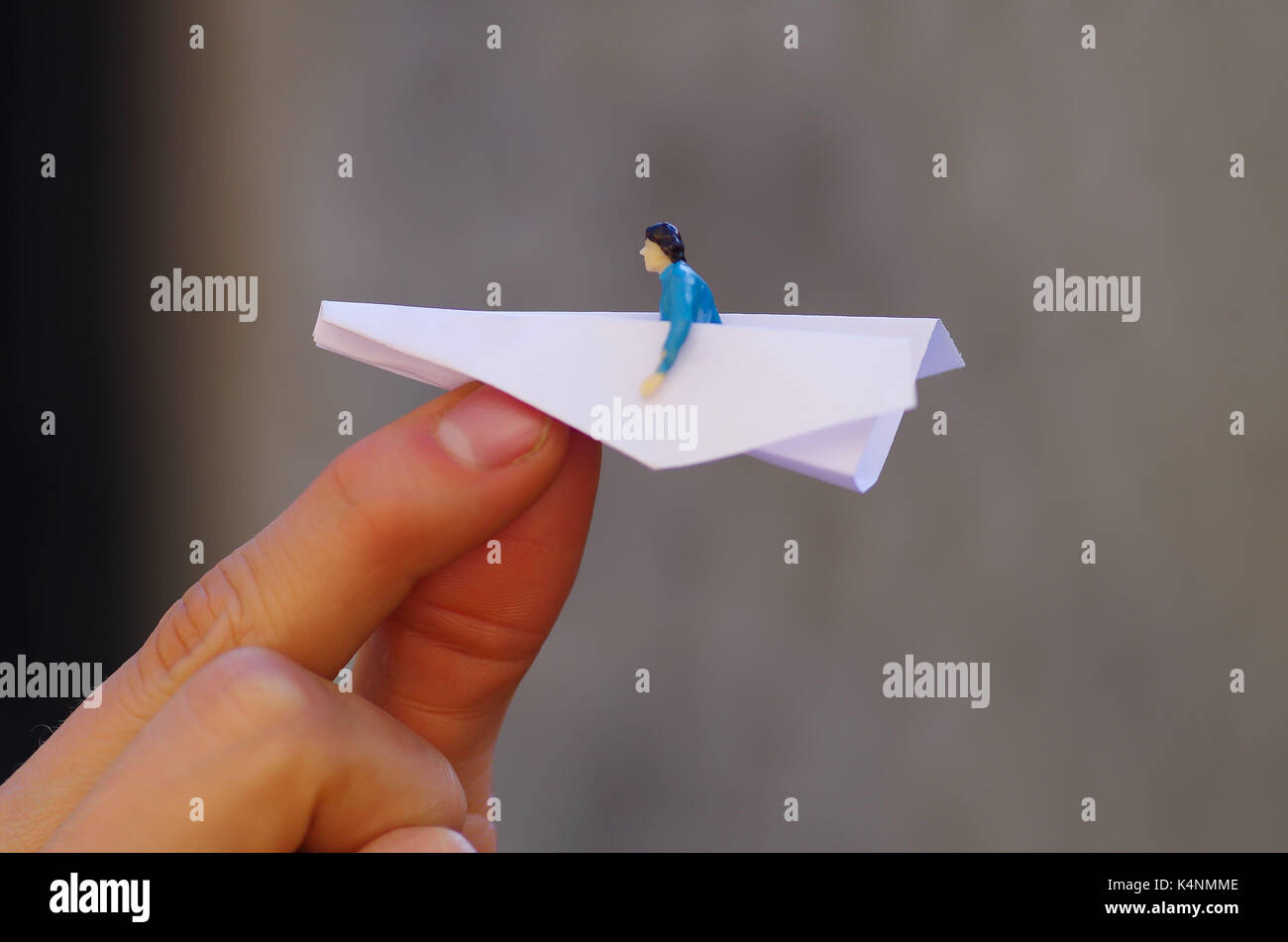 Miniature little people, man inside of a paper airplane in a blurred ...