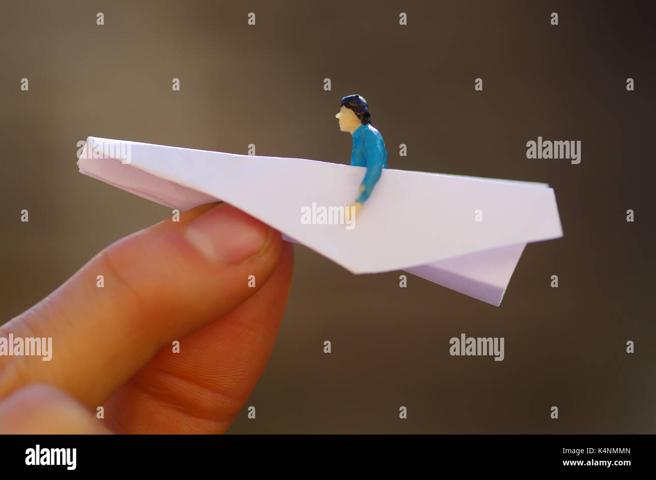 Miniature little people, man inside of a paper airplane in a blurred ...
