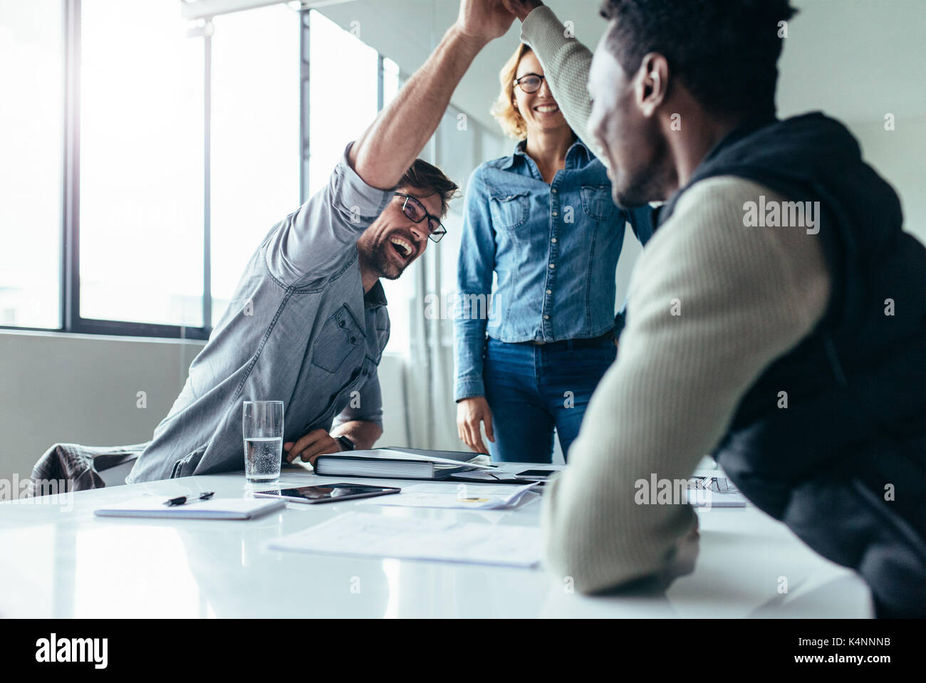 Two colleagues giving high five in meeting. Business people celebrating ...