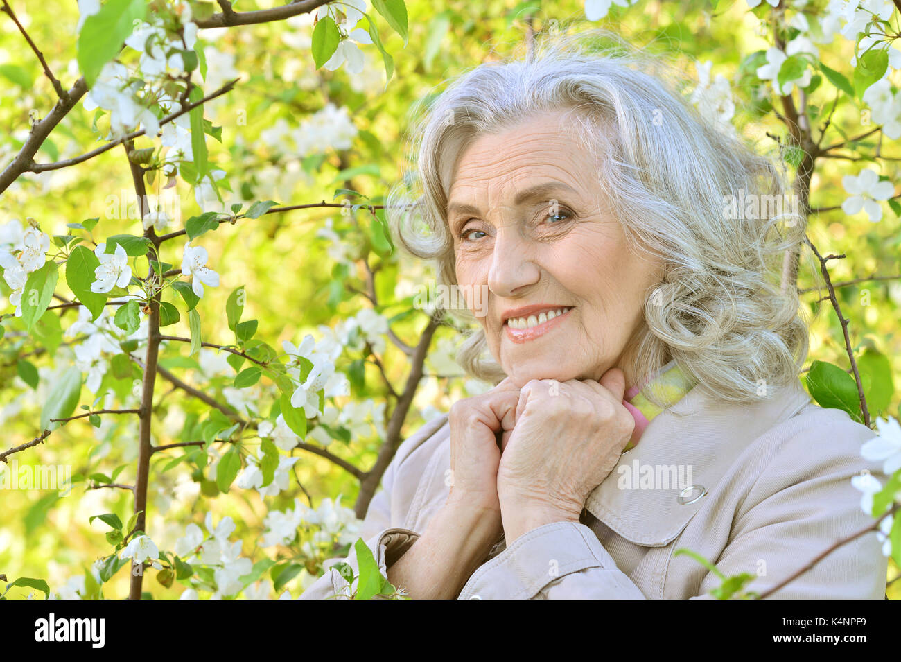 beautiful senior woman standing near blooming tree Stock Photo - Alamy