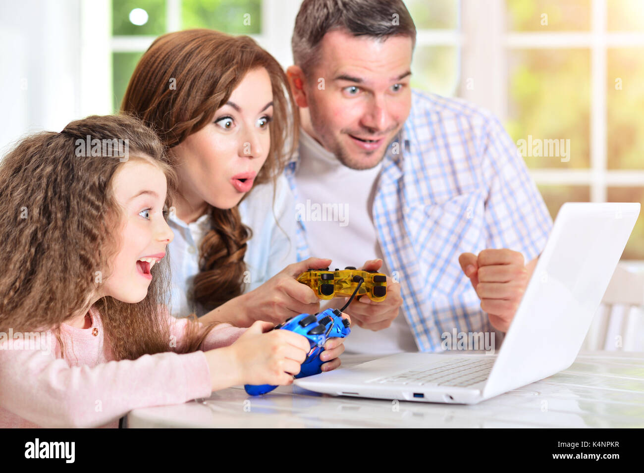 Happy family playing computer game on laptop Stock Photo - Alamy