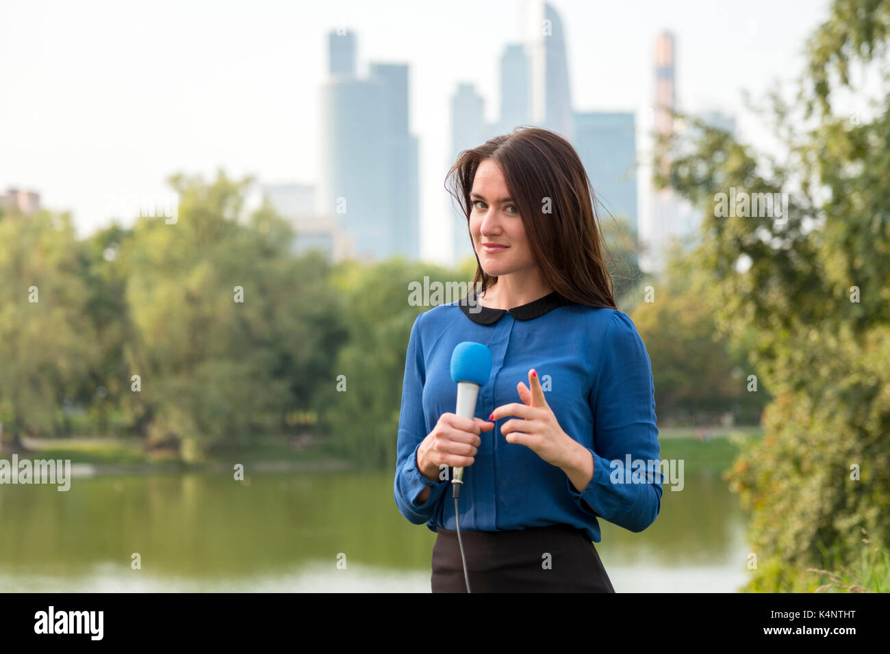 Pretty journalist is reporting on a business center background Stock ...