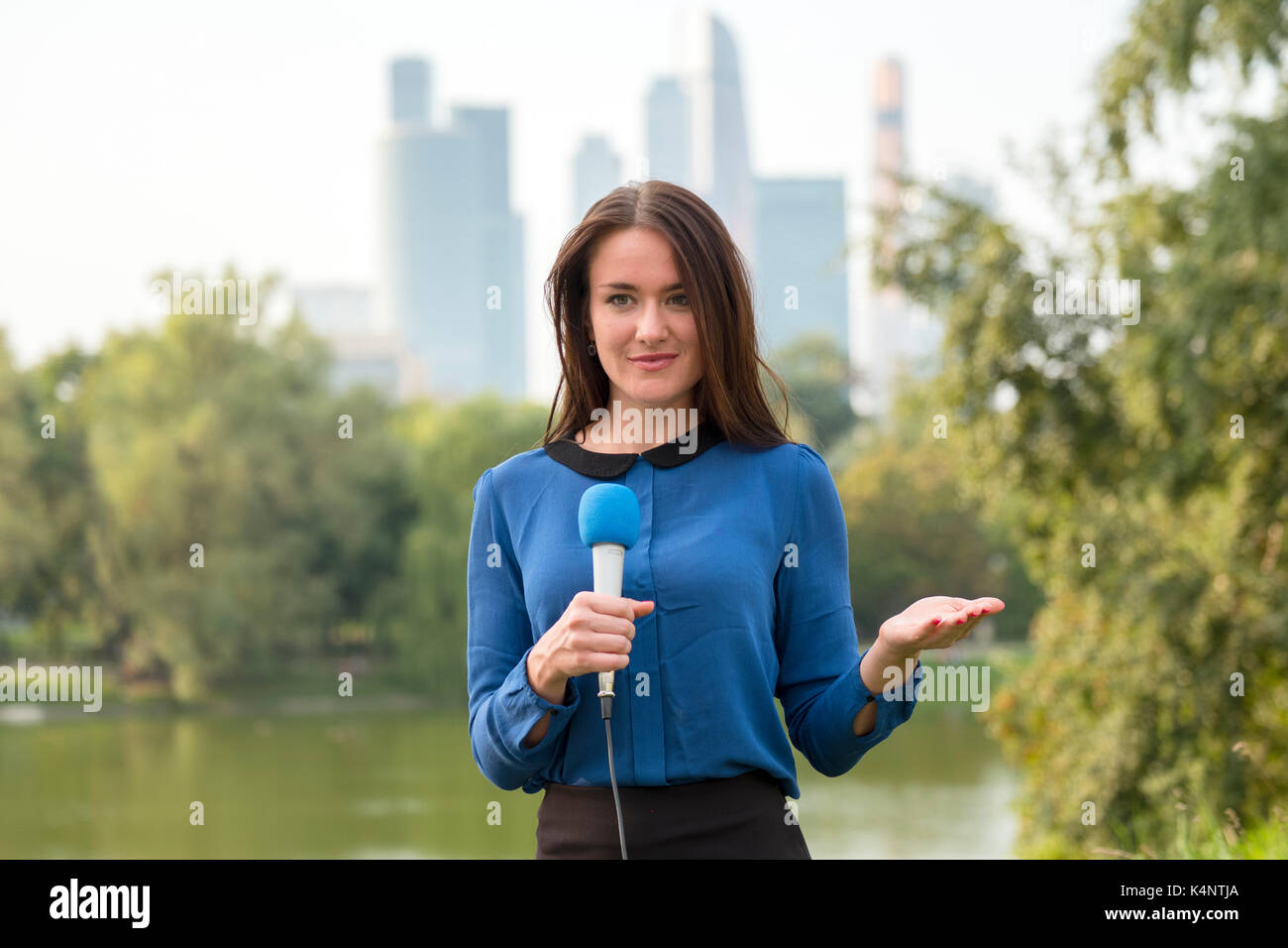 Pretty journalist is reporting on a business center background Stock ...