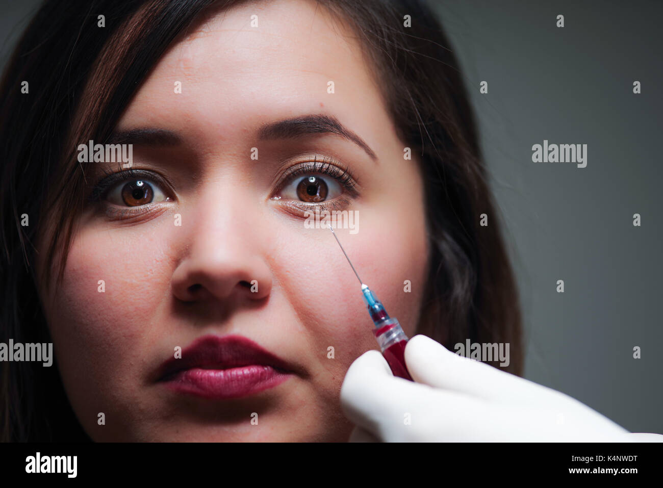 Portrait of a scary beautiful woman, with a needle injection treatment ...