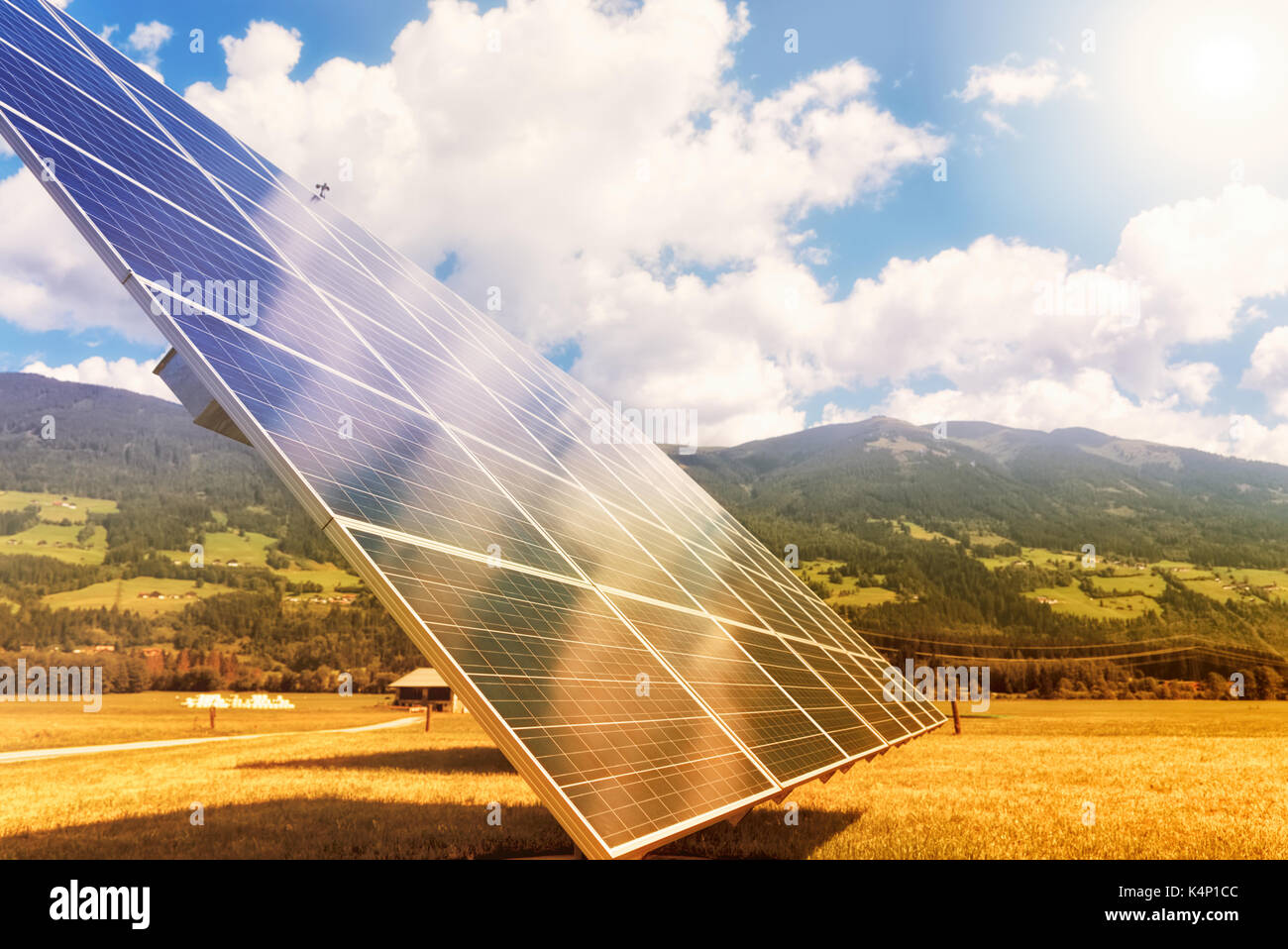 solar panels against mountains landscape against blue sky with clouds ...