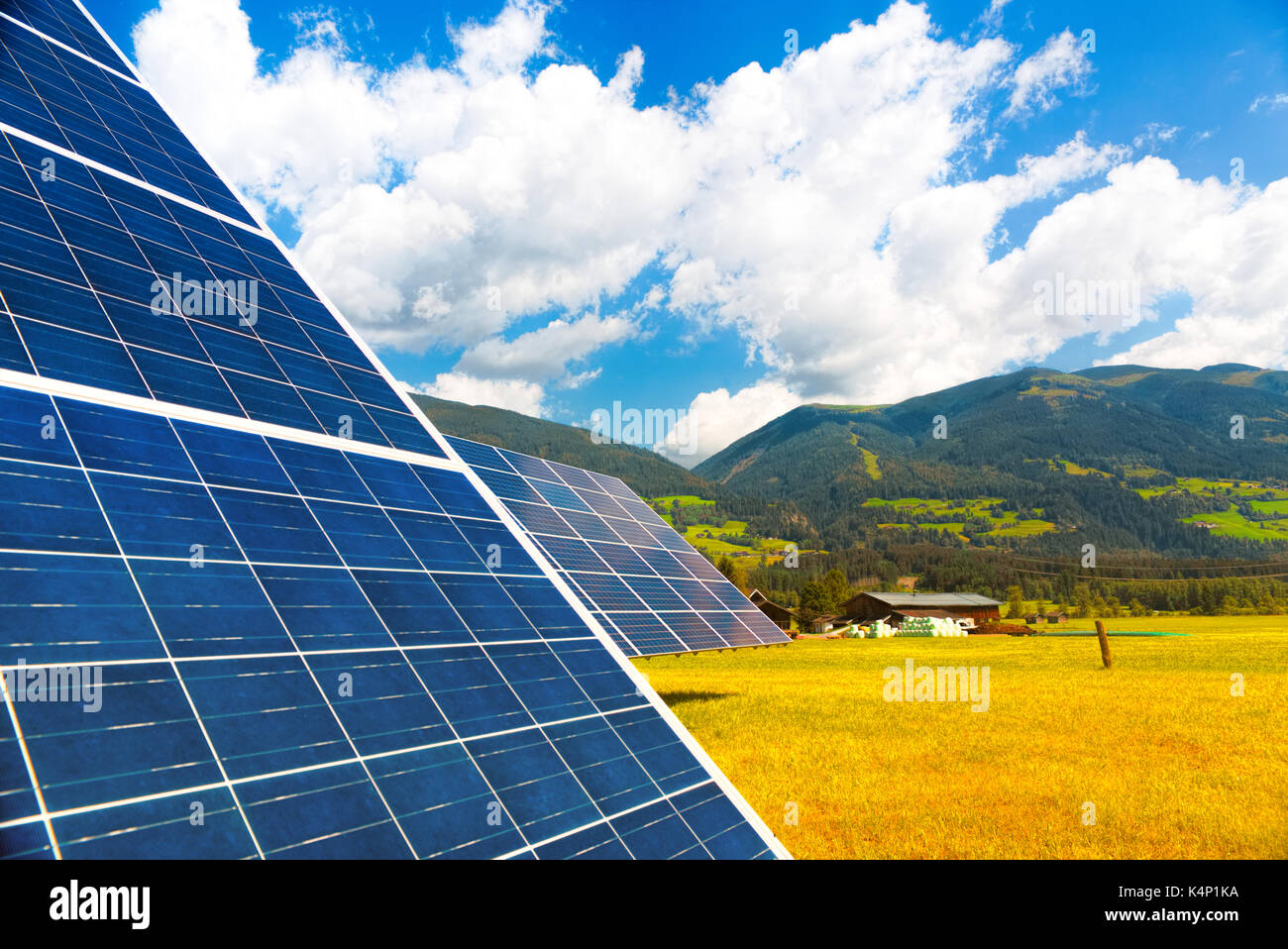 solar panels against mountains landscape against blue sky with clouds ...