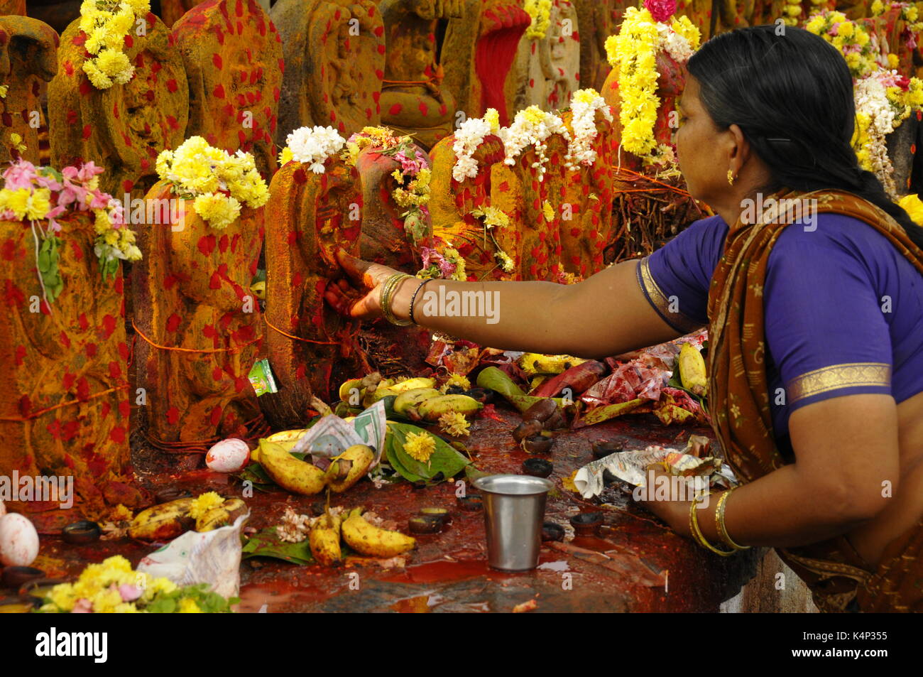 Woman placing an offering at the shrine, Tiruchirappali, India Stock ...