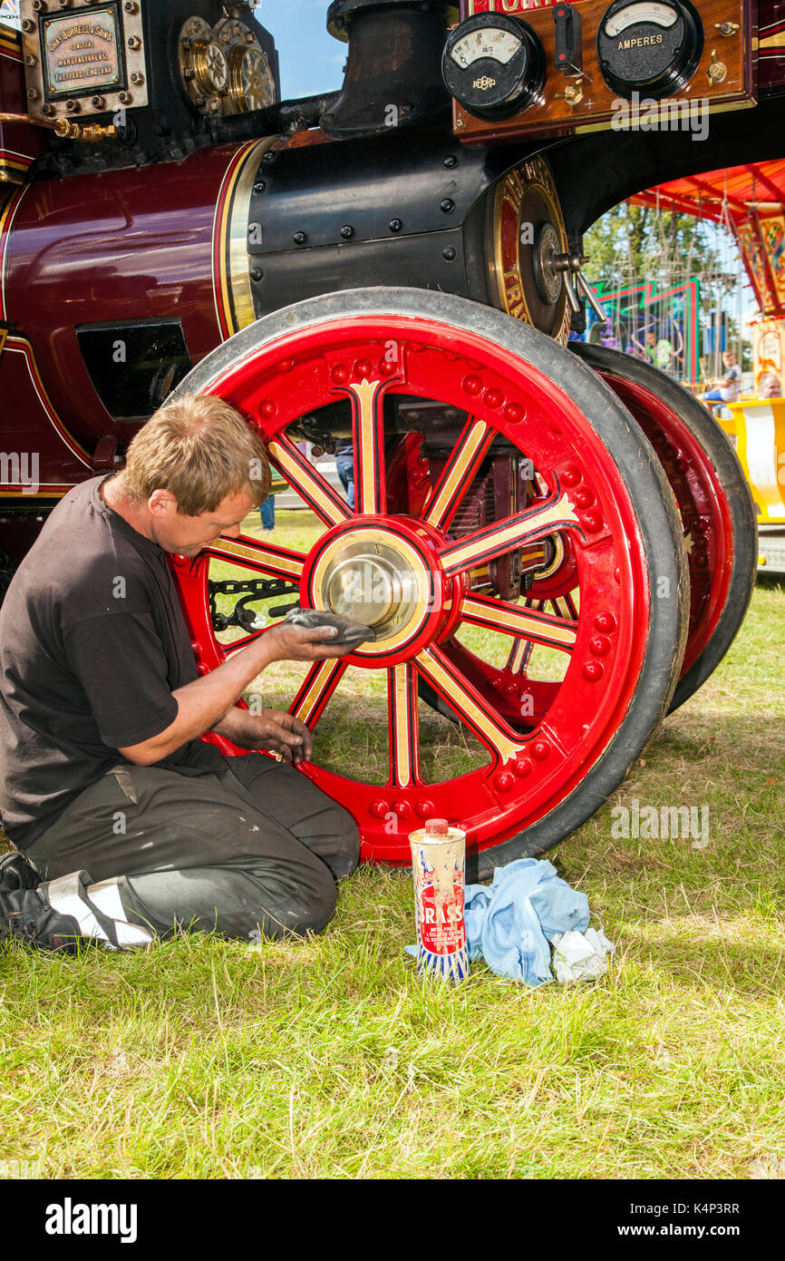 Man cleaning and polishing his vintage steam traction engine at the ...