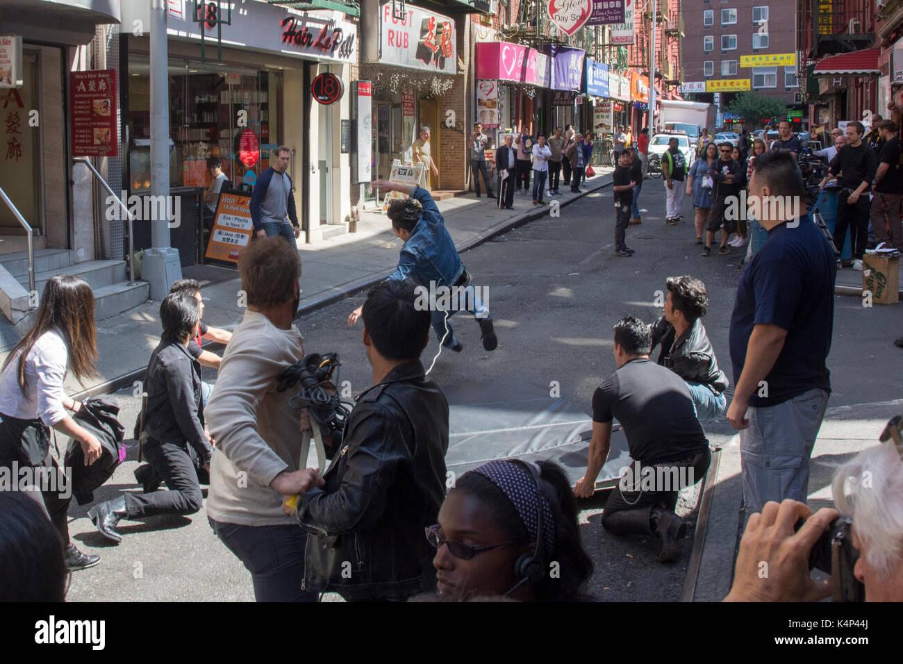 Movie stuntmen perform a fall during filming on Pell Street in New York ...