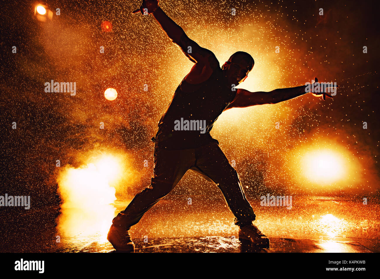 Young man break dancer dramatic silhouette standing in club with lights ...