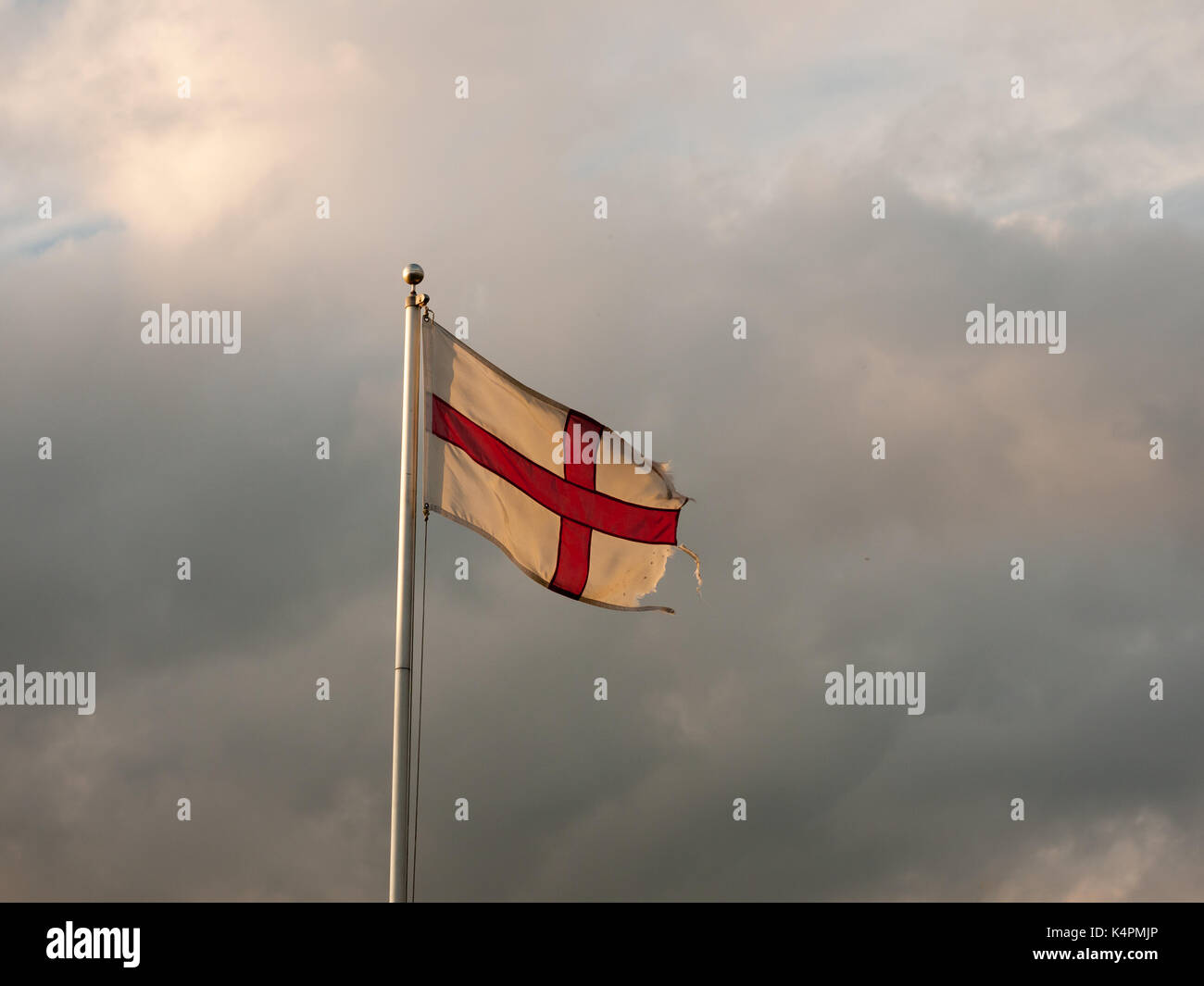 england flag flying with cloudy dramatic skies during sunset; Essex ...