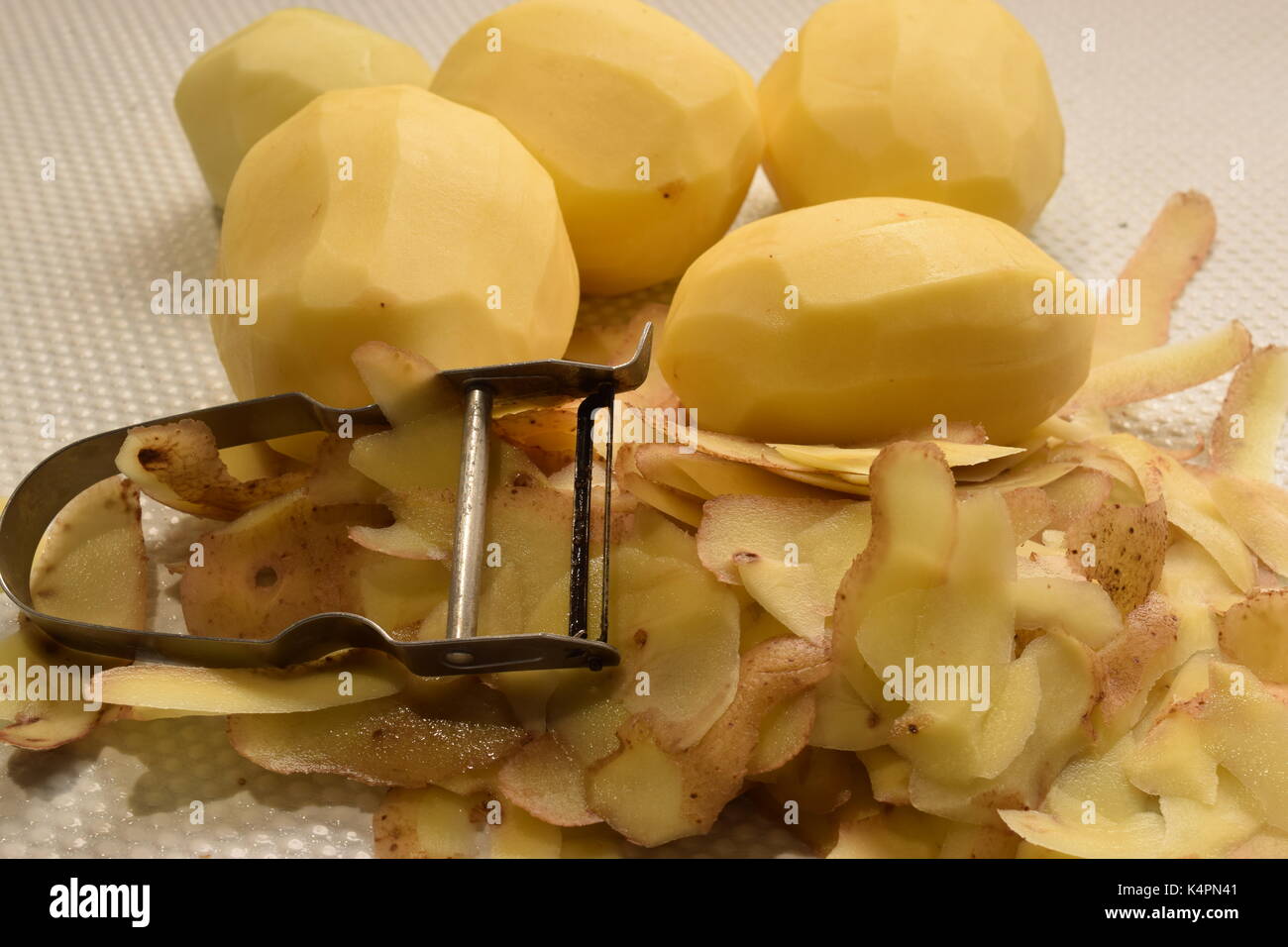 Small round peeled potatoes against a white background Stock Photo - Alamy