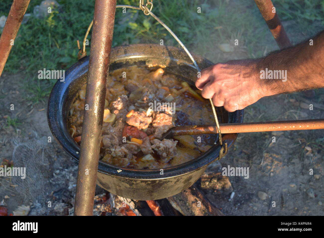 Juicy bubbling stew in a large pot cooking outdoors Stock Photo - Alamy