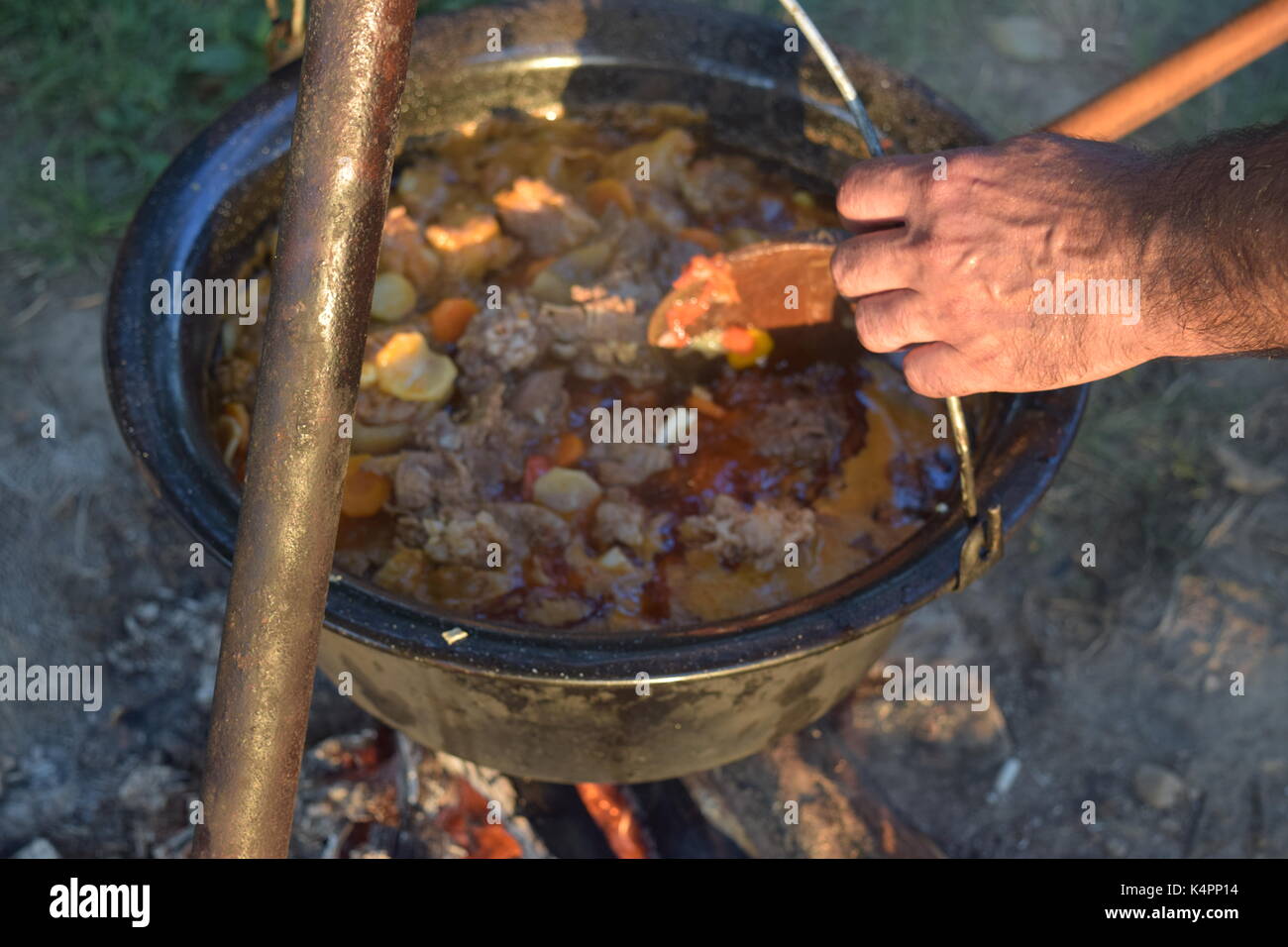 Male hands preparing large pot of stew outside Stock Photo - Alamy