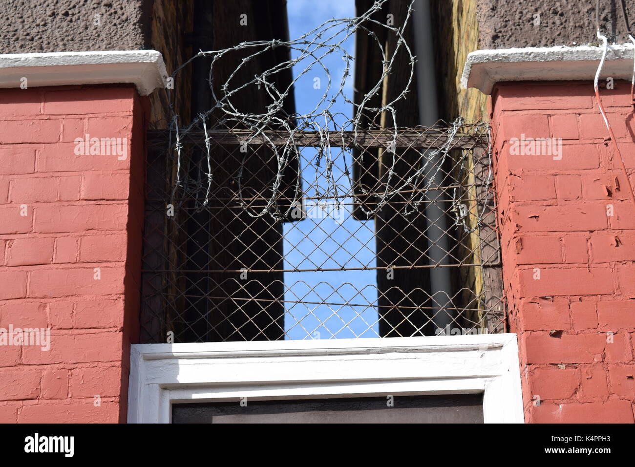 Barbed wire between two walls Stock Photo - Alamy