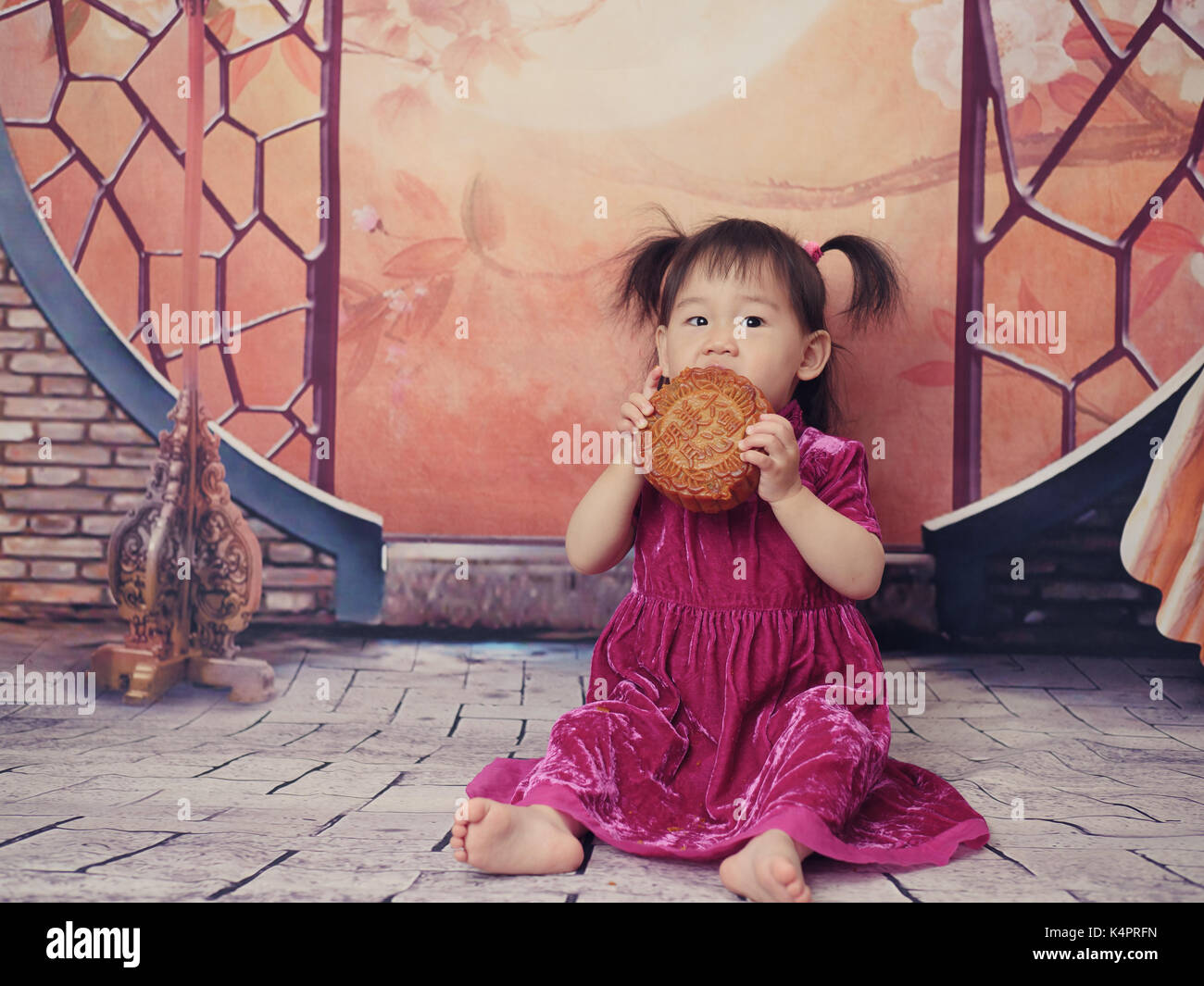 Baby girl eating Chinese moon cake Stock Photo - Alamy