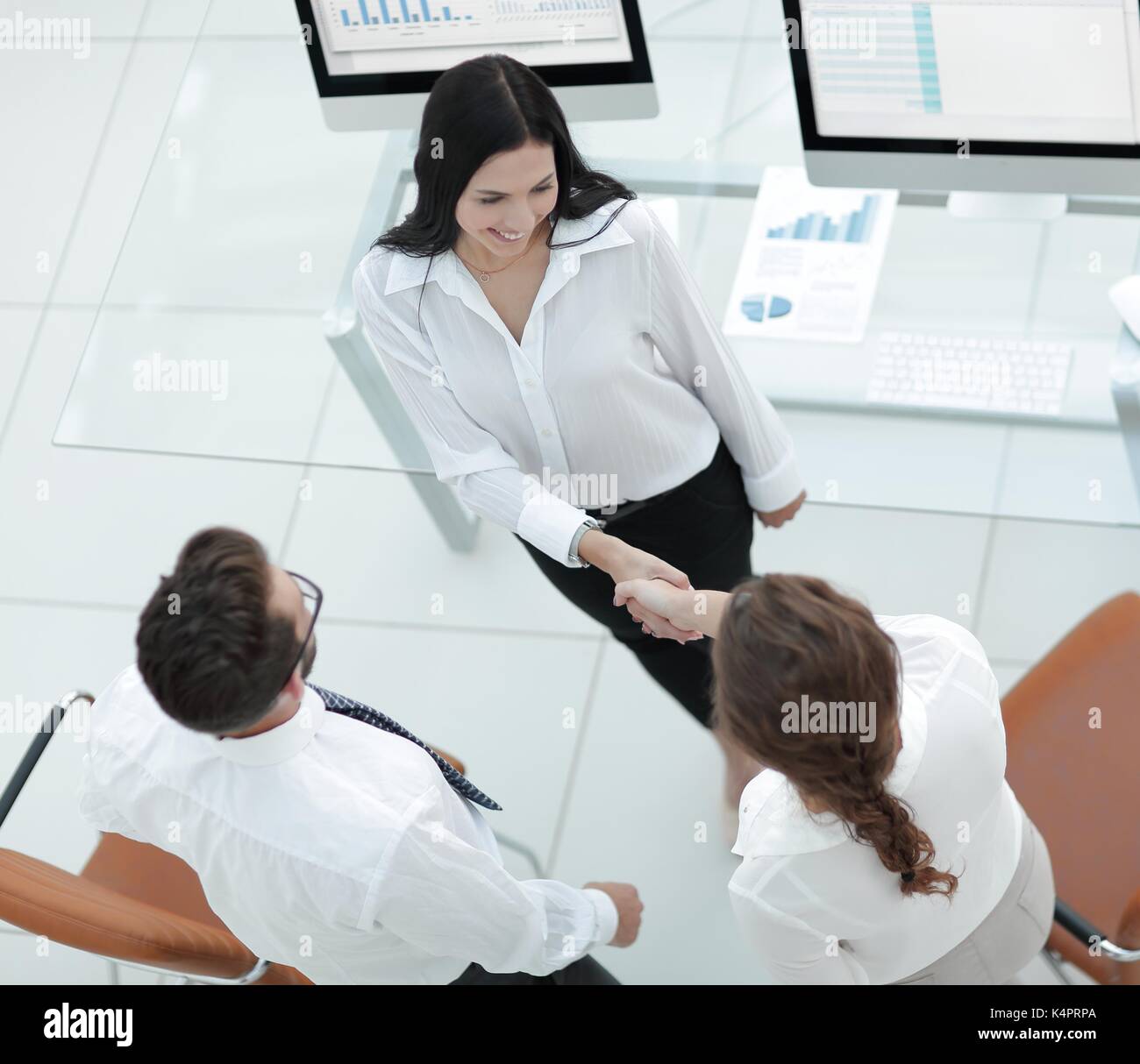 handshake manager and employee near the workplace. photo with copy ...