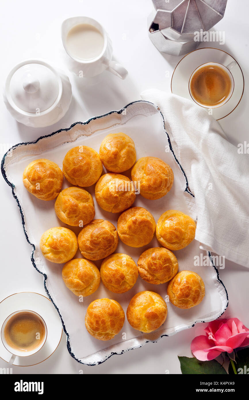 profiteroles and coffee on white trey for sweets . utensils for tea and ...