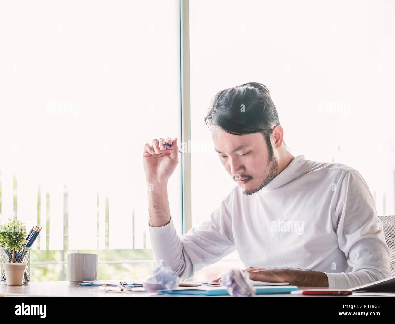 Man with pencil thinking hi-res stock photography and images - Alamy