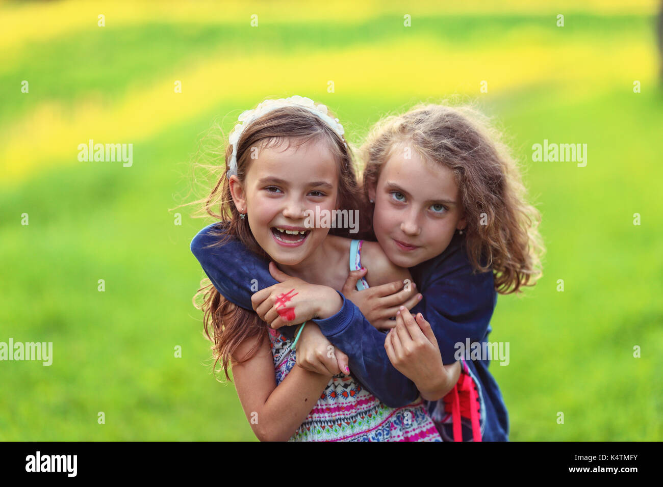 Friendly hugging of two joyful girls Stock Photo - Alamy