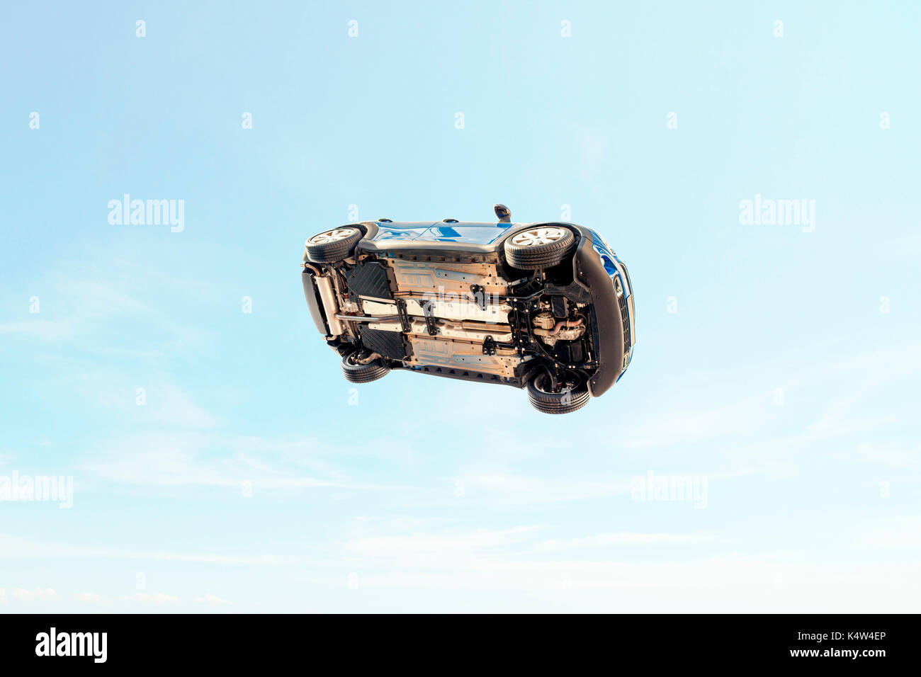 A car flying through the air (in the pale blue sky) with the underside ...