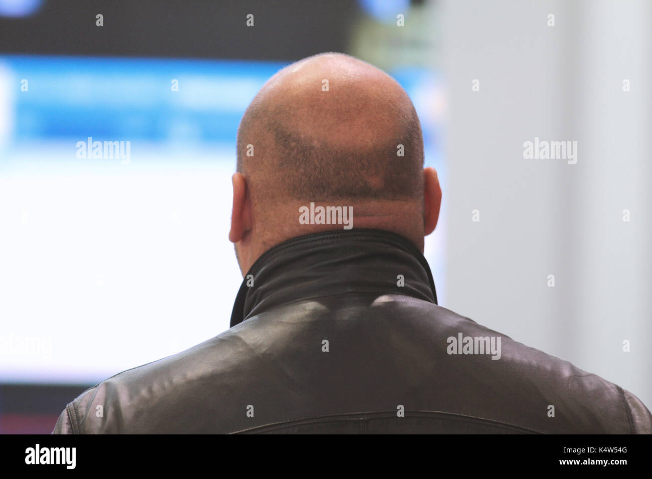 Big bald man in leather jacket at conference hall - rear view Stock ...