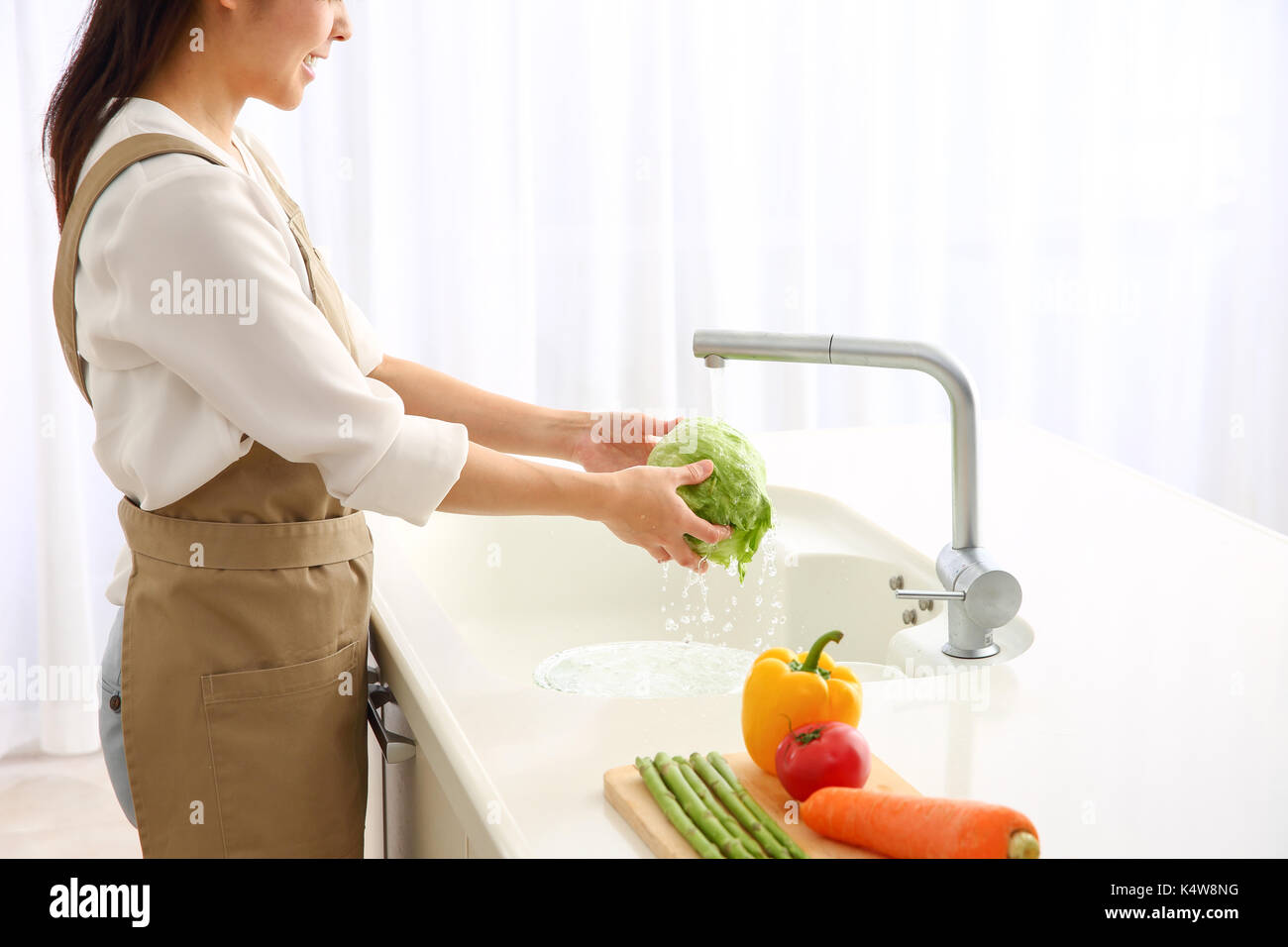 Japanese woman washing vegetables in the kitchen Stock Photo - Alamy