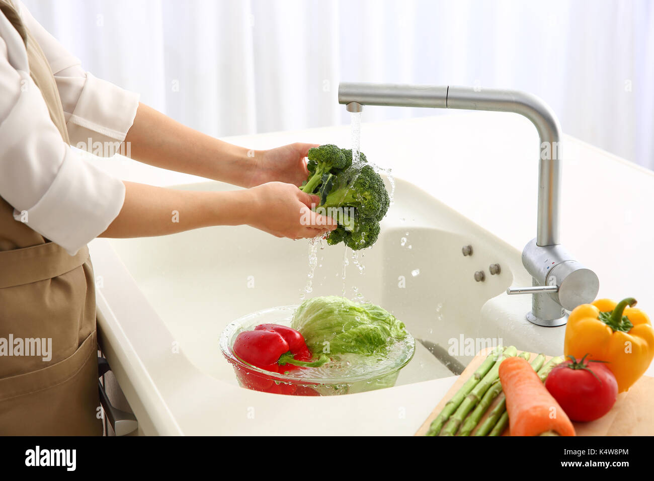 Japanese woman washing vegetables in the kitchen Stock Photo - Alamy
