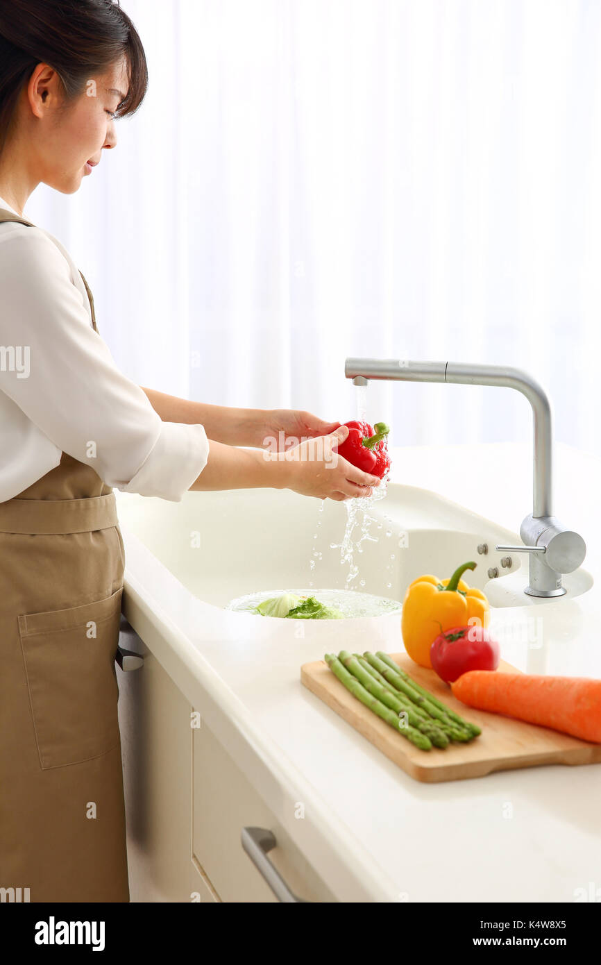 Japanese woman washing vegetables in the kitchen Stock Photo - Alamy
