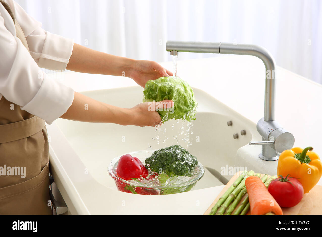 Japanese woman washing vegetables in the kitchen Stock Photo - Alamy