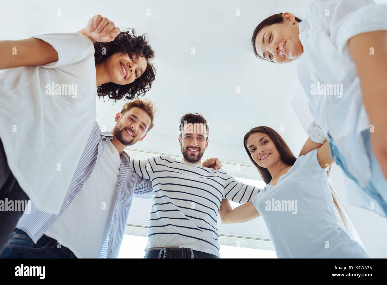 Joyful positive team standing together Stock Photo - Alamy
