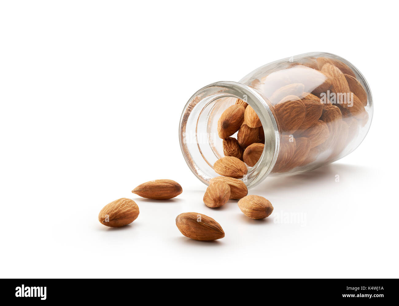 Almonds pouring out from bottle isolated on white Stock Photo - Alamy