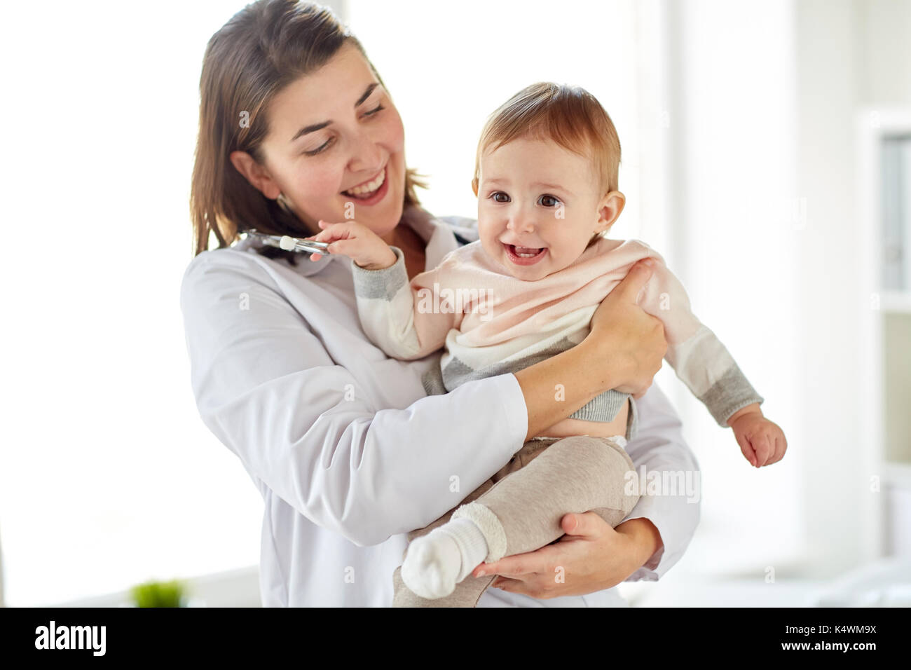 doctor or pediatrician holding baby at clinic Stock Photo - Alamy