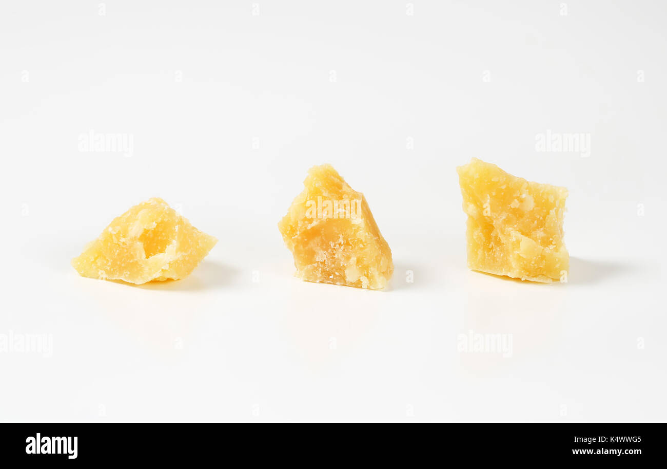 three pieces of parmesan cheese on white background Stock Photo - Alamy