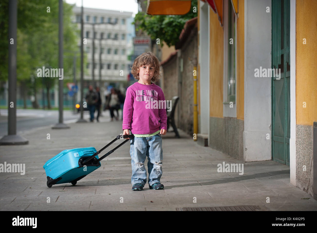Cute little boy with a luggage bag on the street. Growing up and ...