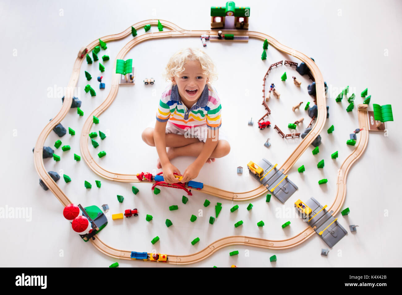 Kids play with toy train railway. Child playing with wooden trains ...