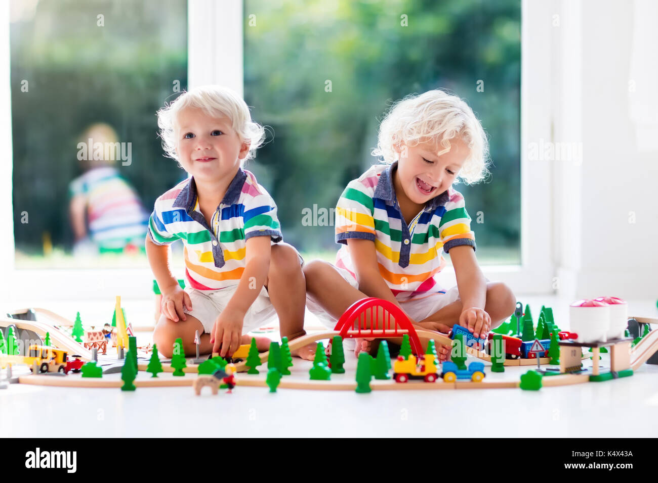 Kids play with toy train railway. Children playing with wooden trains ...
