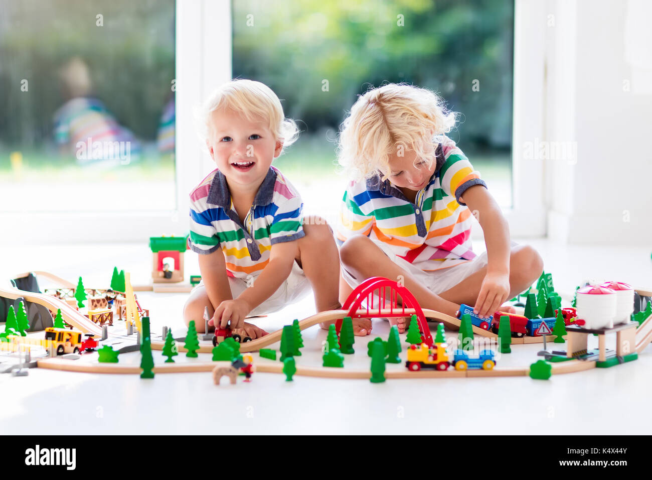 Kids play with toy train railway. Children playing with wooden trains ...